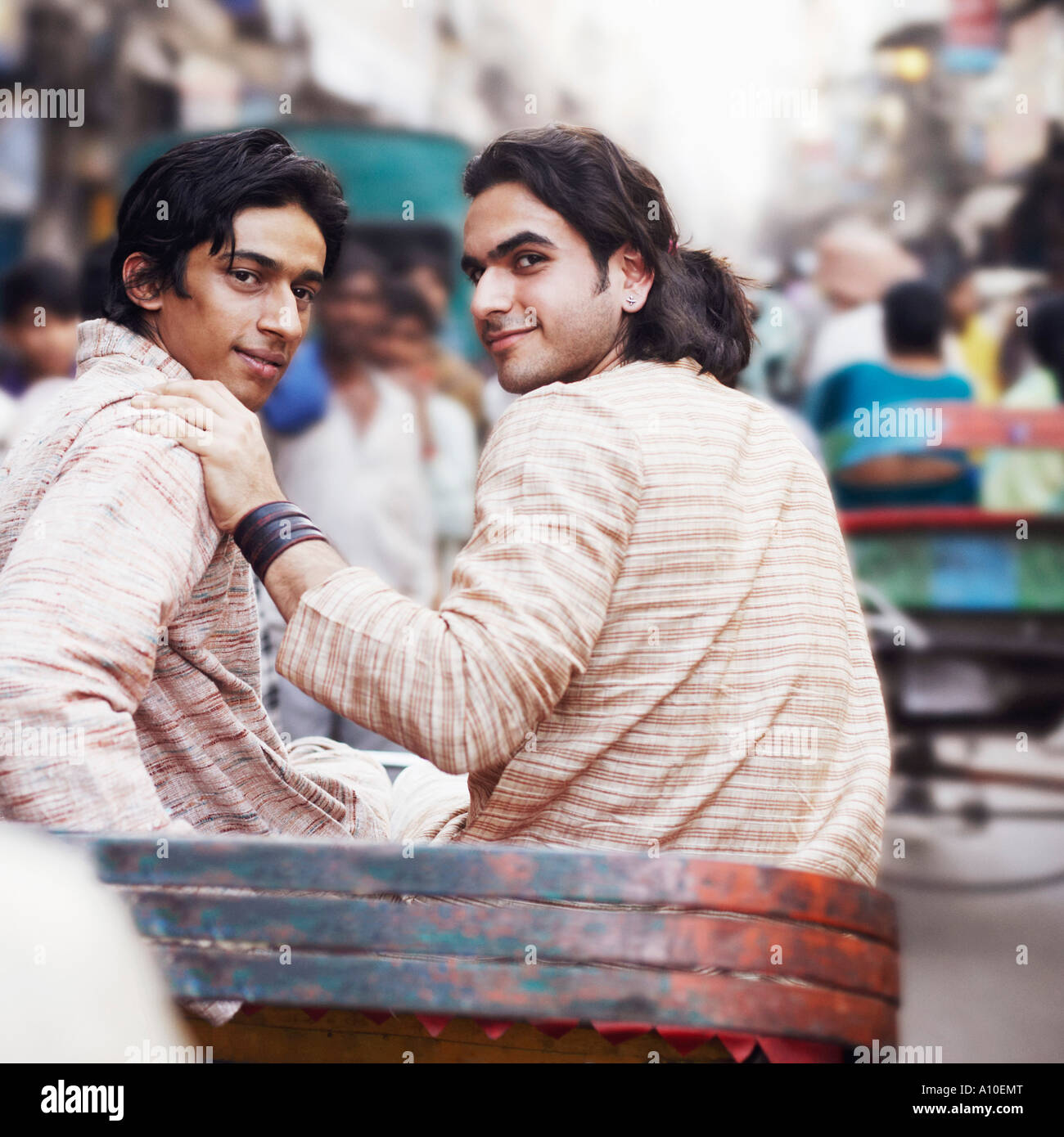 Rear view of two young men sitting in a rickshaw Stock Photo - Alamy