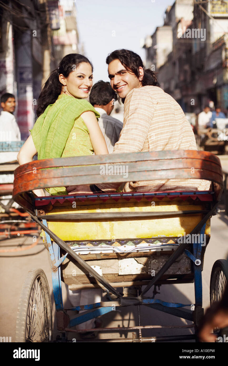 Rear view of a young couple sitting in a rickshaw Stock Photo - Alamy