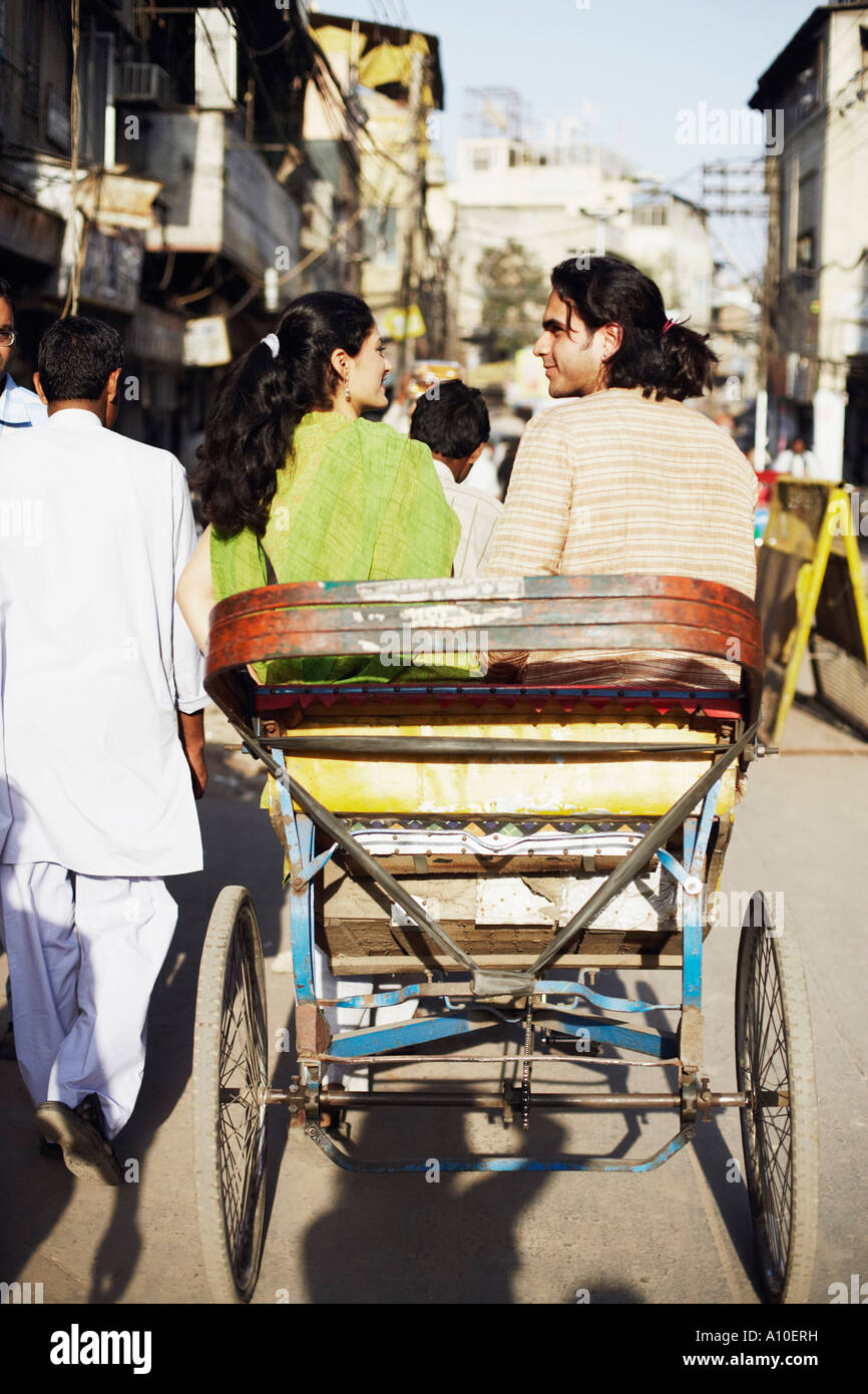 Rear view of a young couple sitting in a rickshaw Stock Photo - Alamy