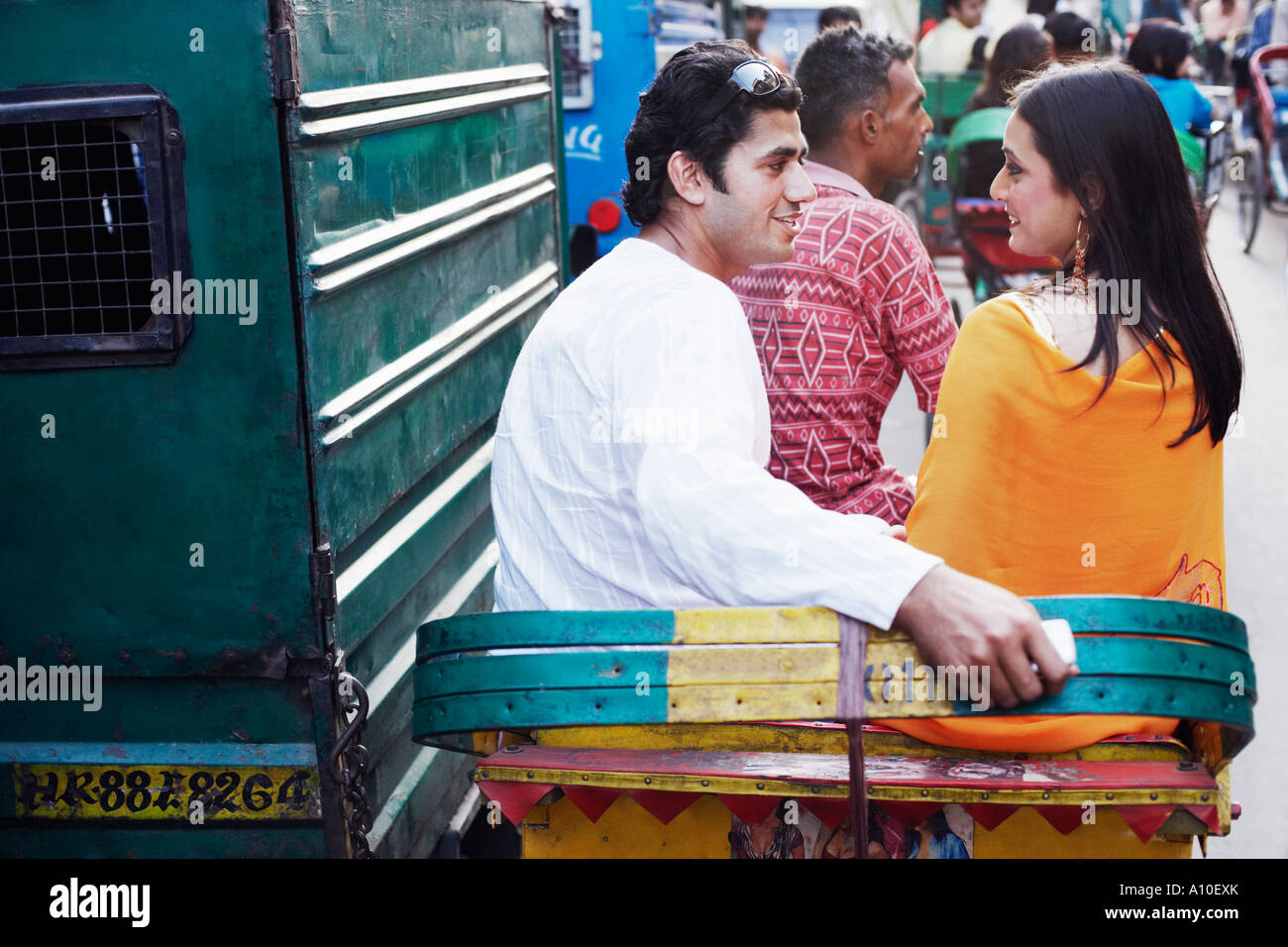 Rear view of a young couple sitting in a rickshaw Stock Photo - Alamy
