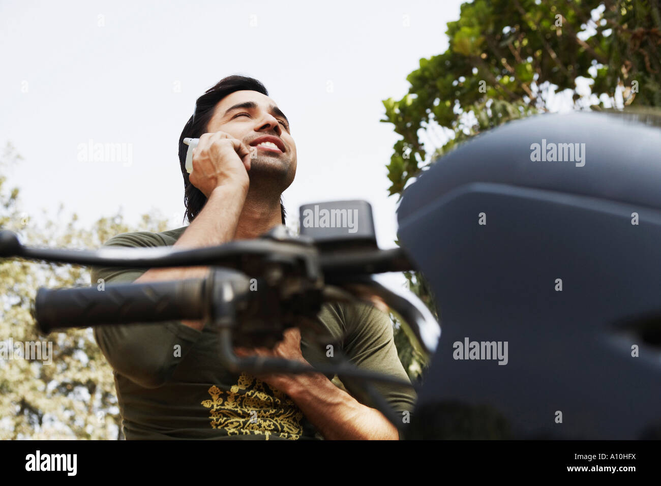 Young man sitting on a motorcycle and using a mobile phone Stock Photo ...