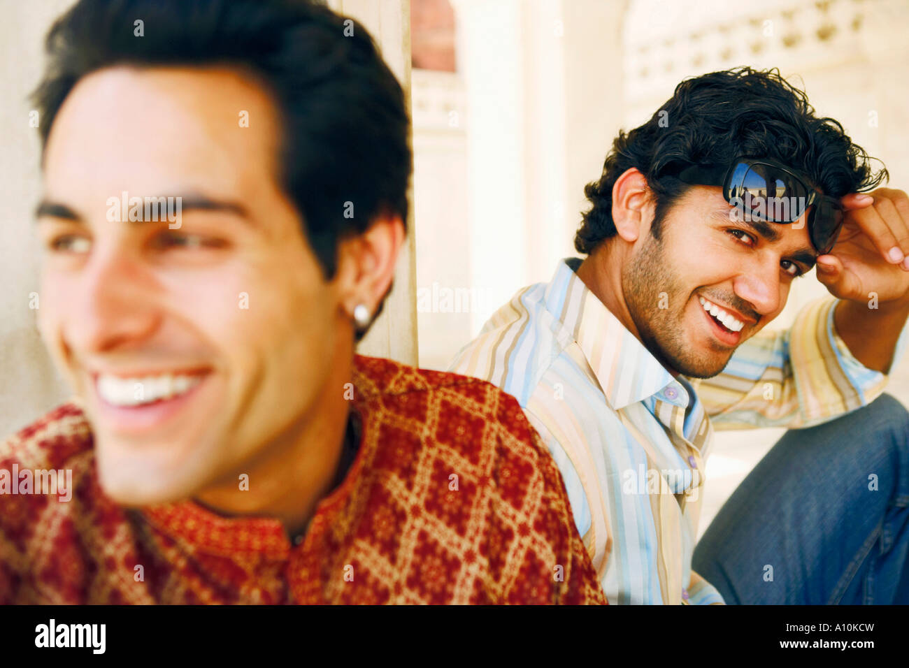 Portrait of a young man sitting with another young man behind him Stock ...