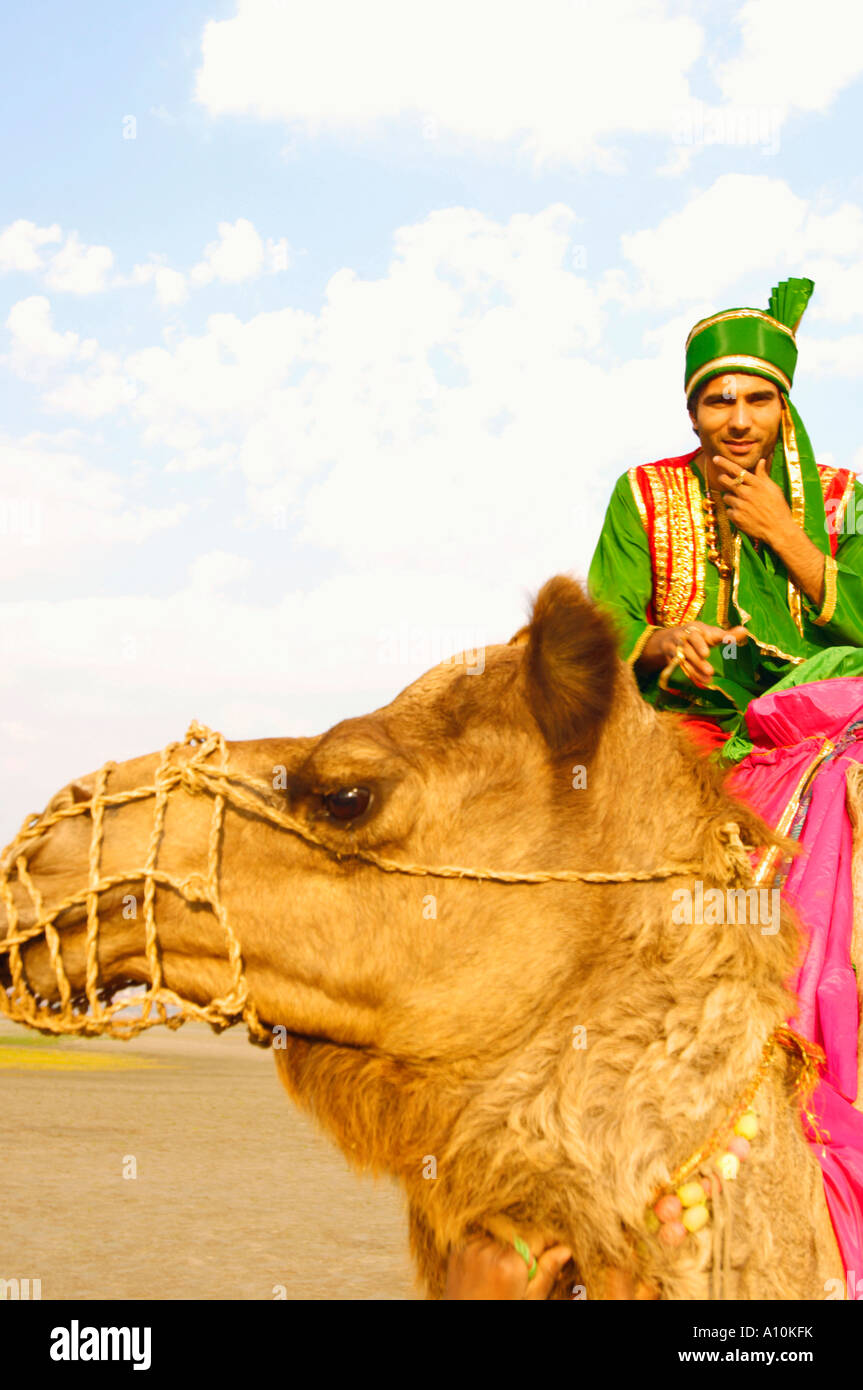 Low angle view of a young man riding a camel Stock Photo - Alamy