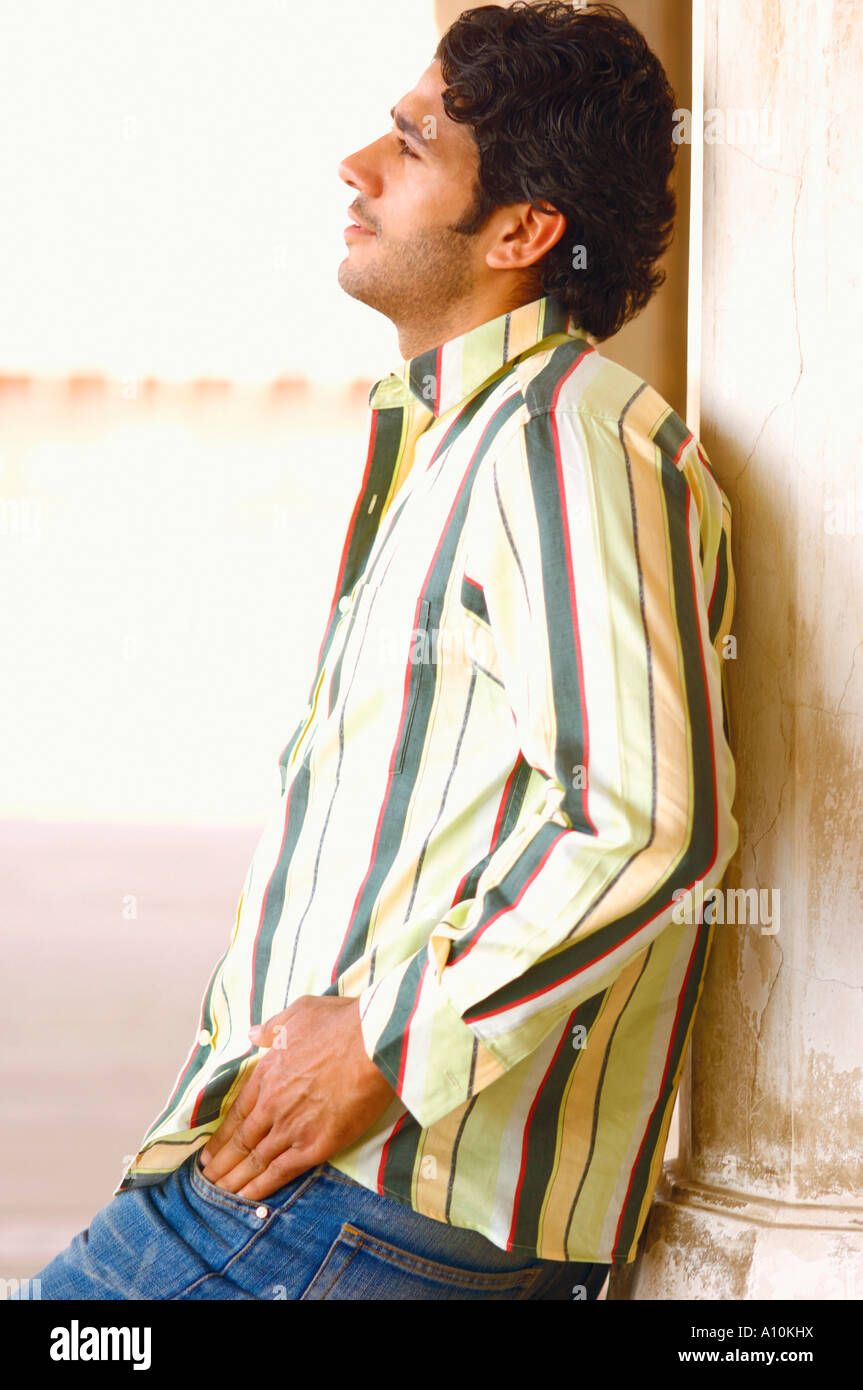Side profile of a young man leaning against a column Stock Photo - Alamy