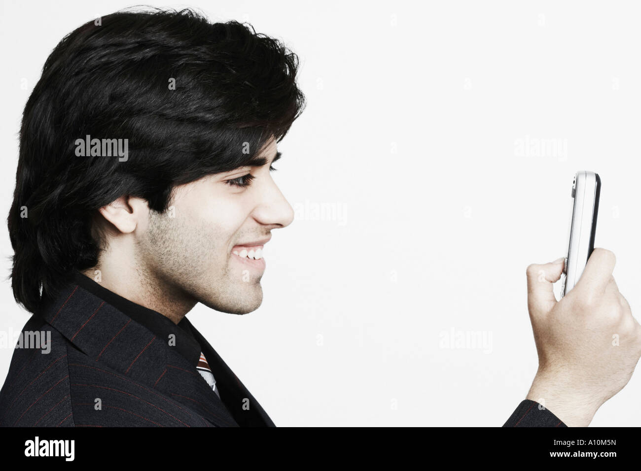 Side profile of a businessman operating a mobile phone Stock Photo - Alamy