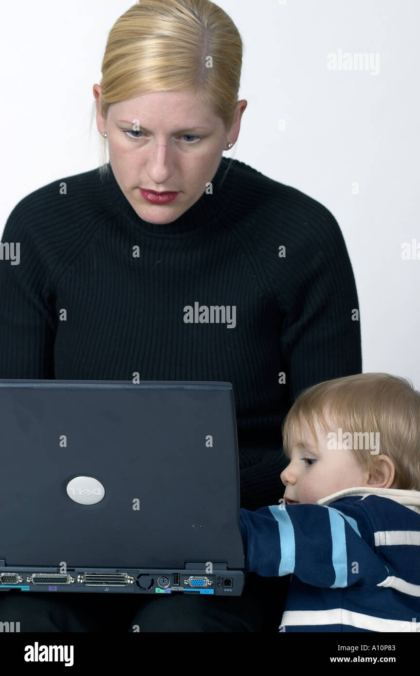 Working mother types on computer with son Model released and property ...