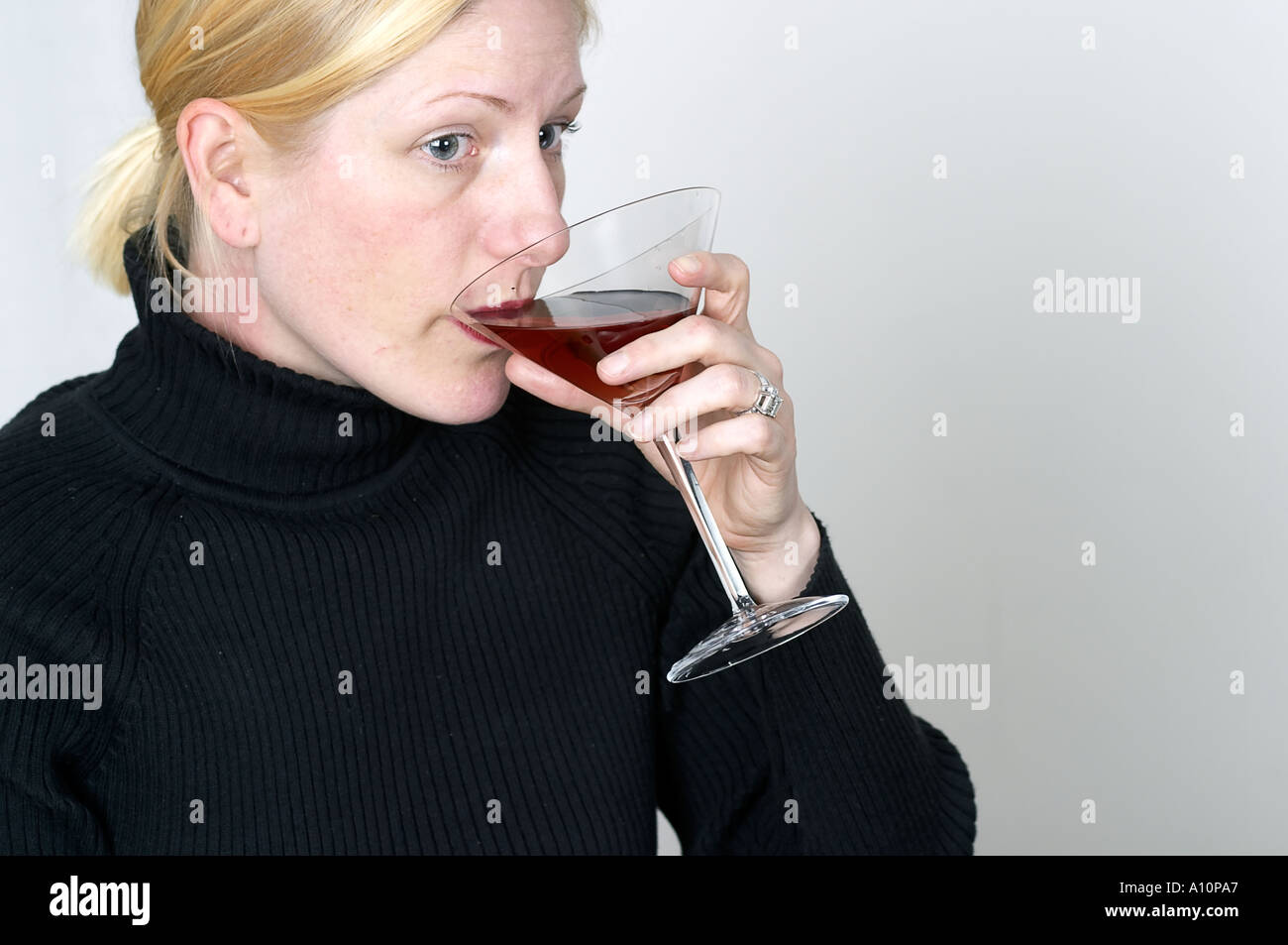 Woman sips drink in glass Model released and Property released Image ...