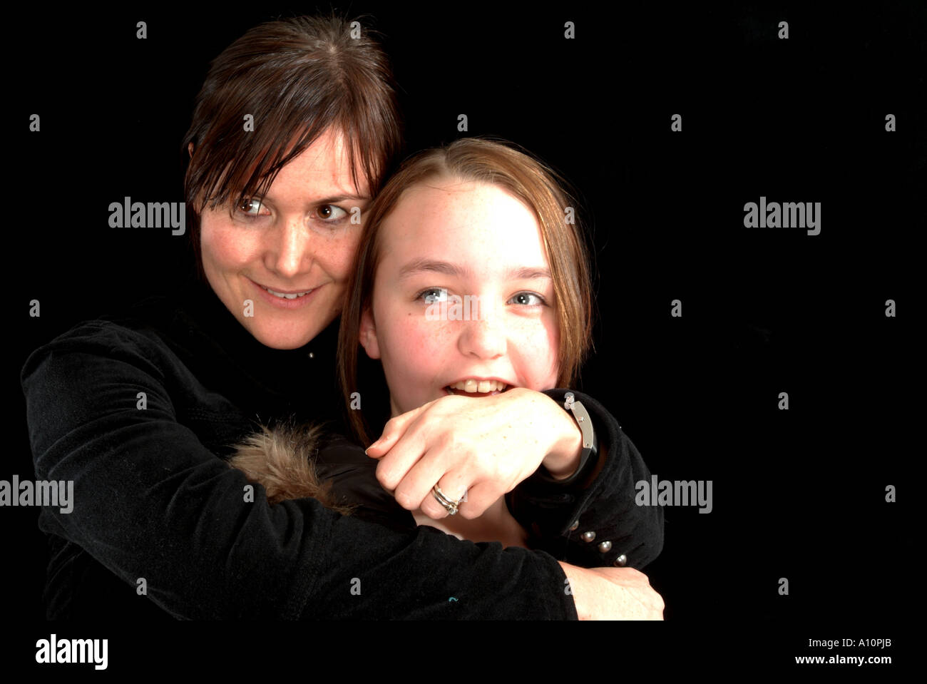 young teenage girl posing with mother figure biting her hand Stock ...