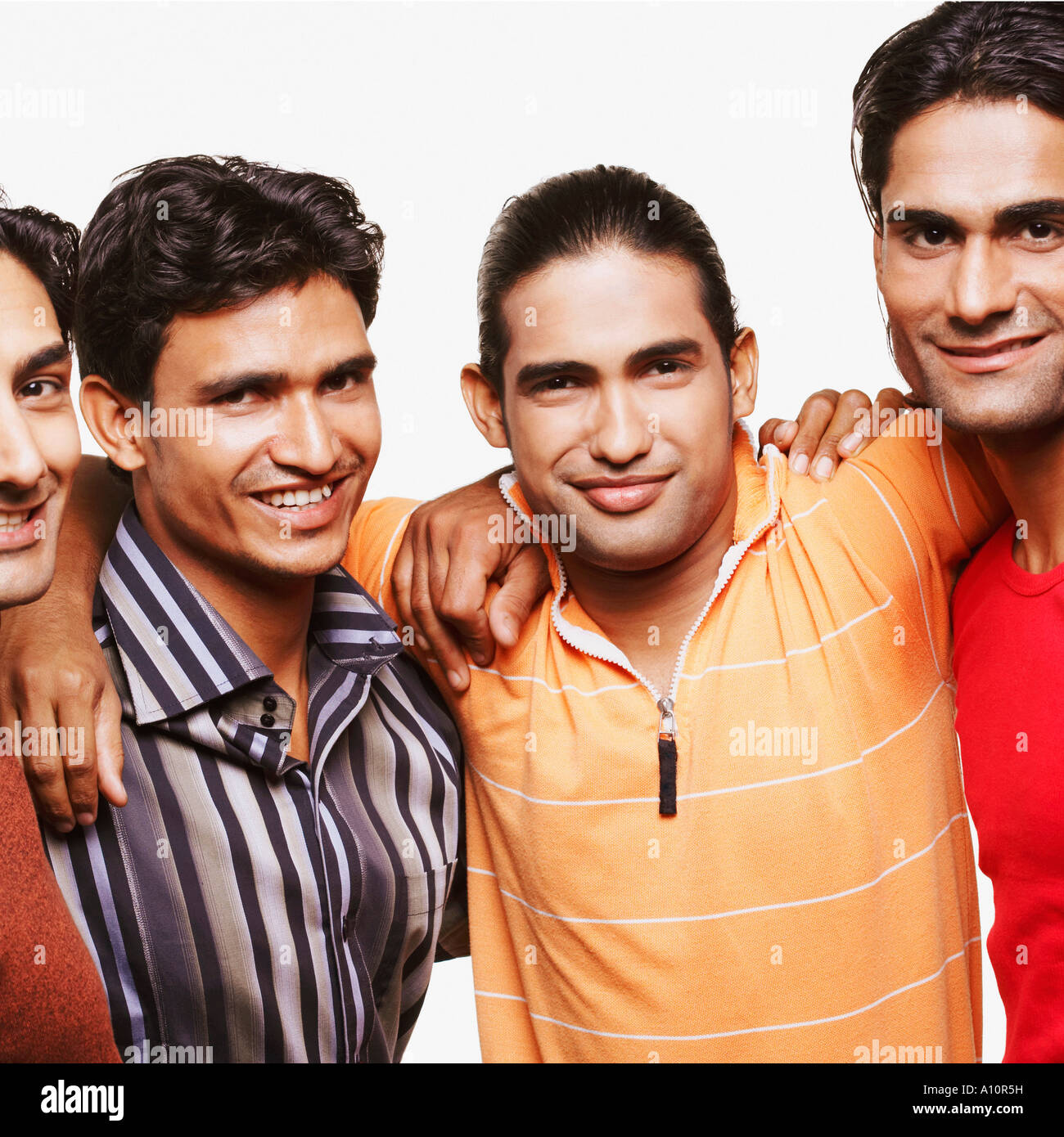 Portrait of four young men with their arms around each other and ...