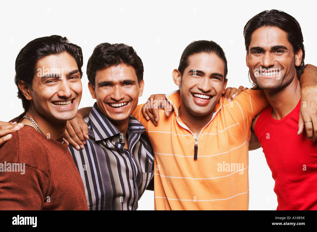Portrait of four young men standing side by side with their arms around ...