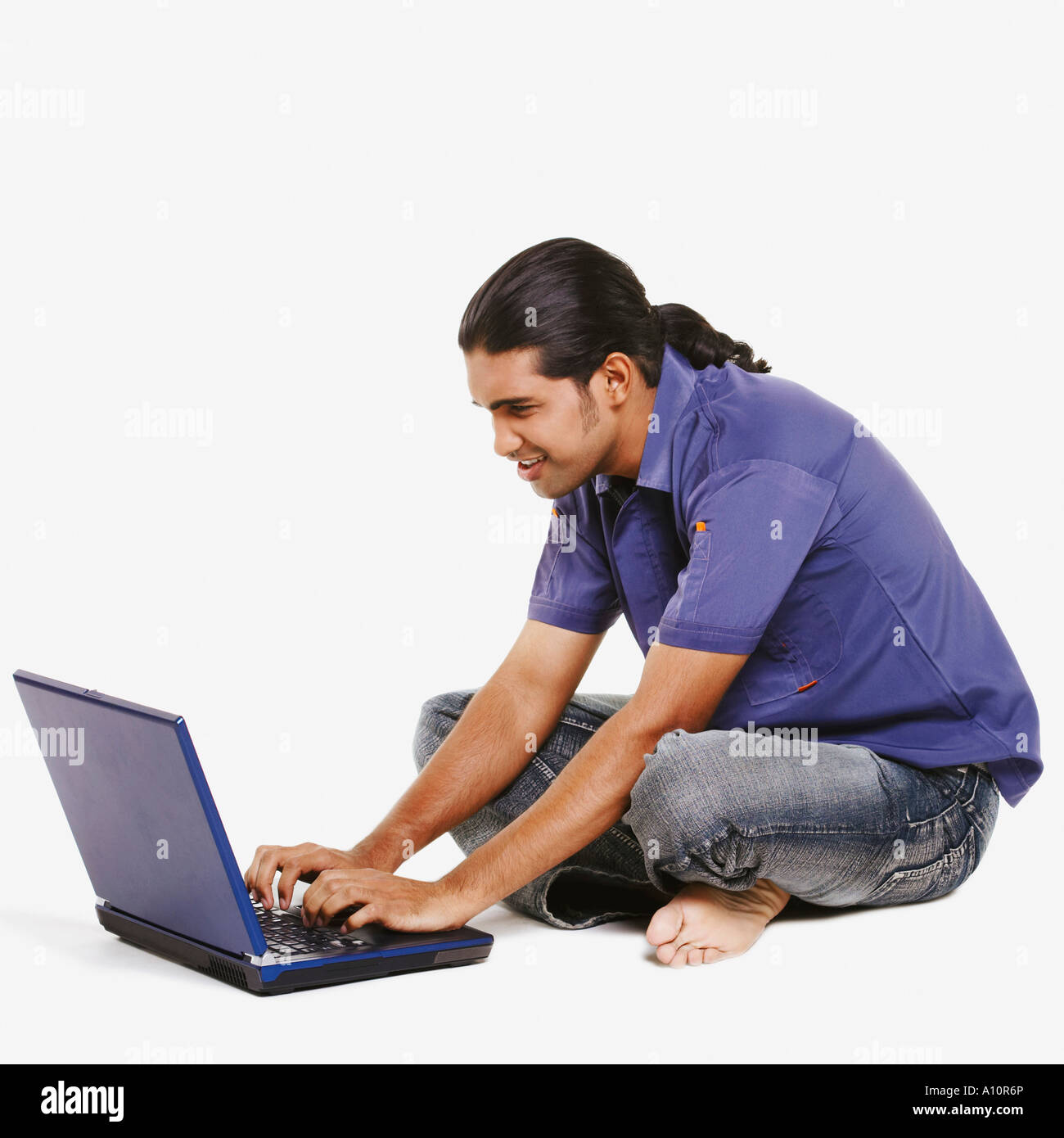 Young man sitting on the floor and using a laptop Stock Photo - Alamy