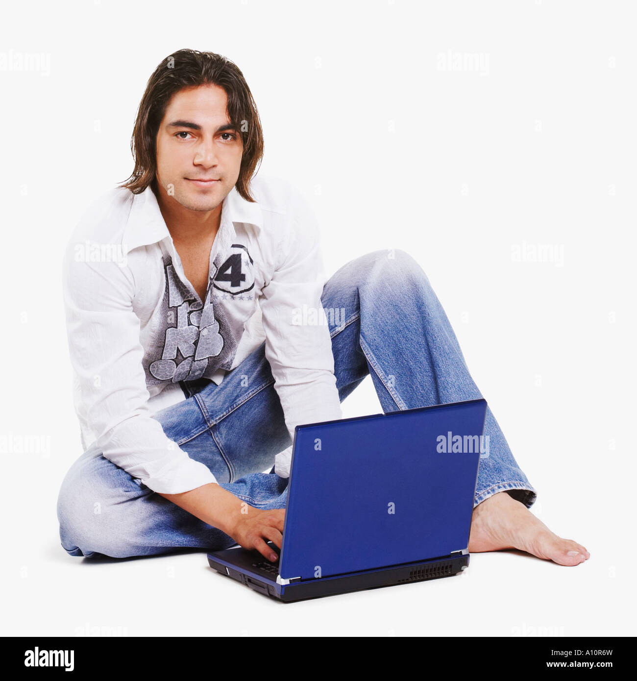 Portrait of a young man sitting on the floor and using a laptop Stock ...