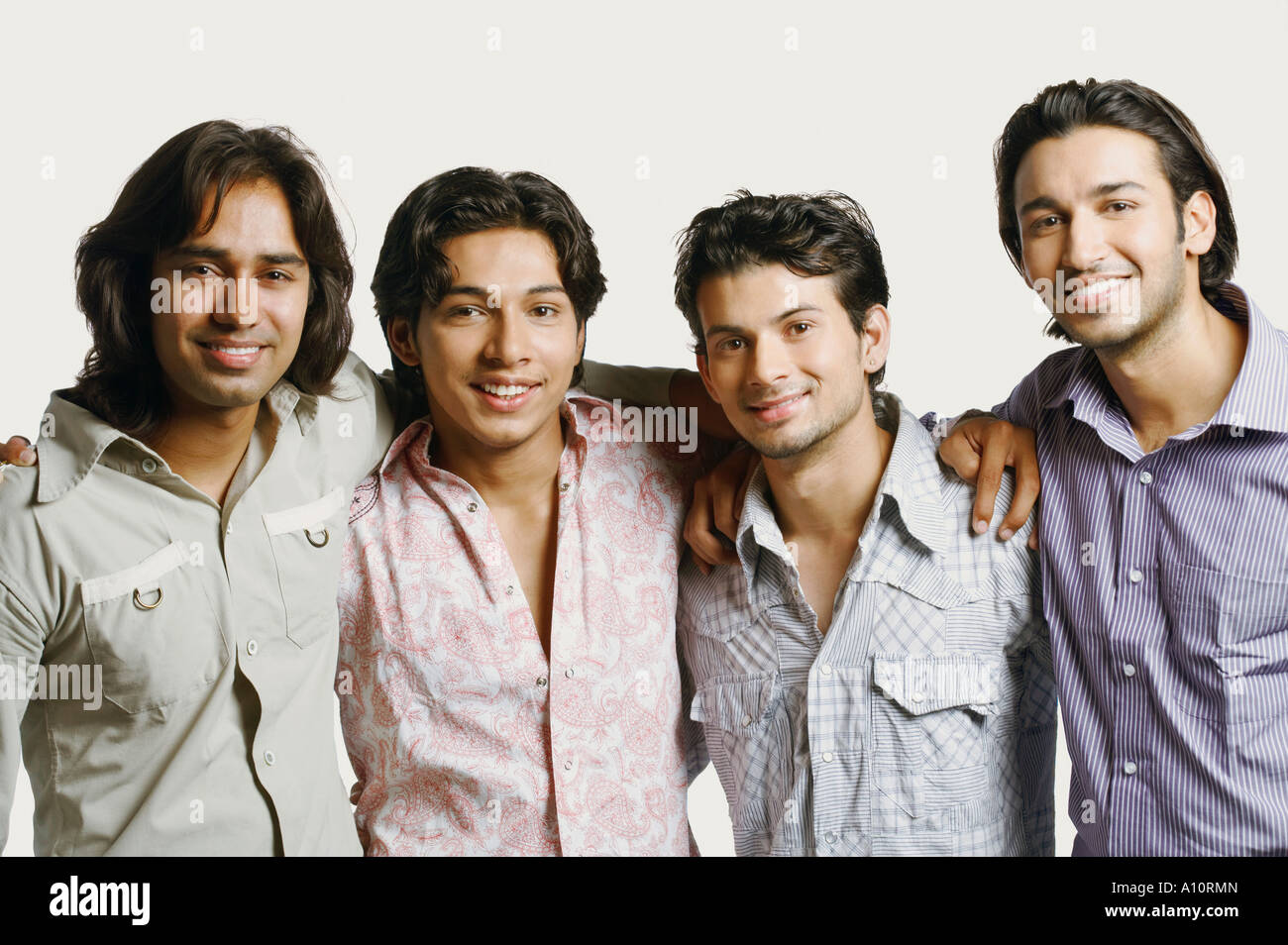 Portrait of four young men with their arms around each other and ...
