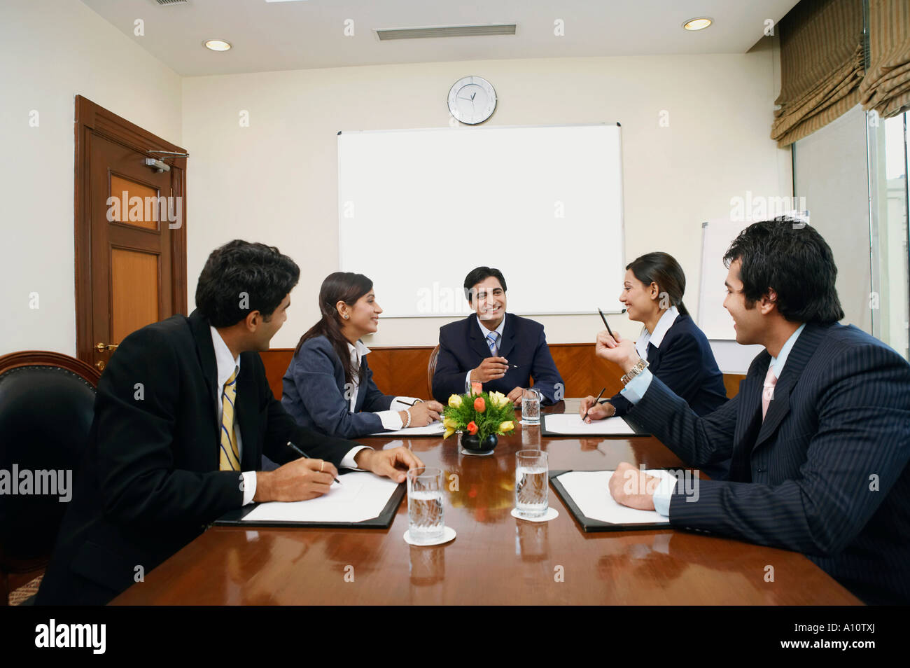 Five business executives at a meeting in a conference room Stock Photo ...
