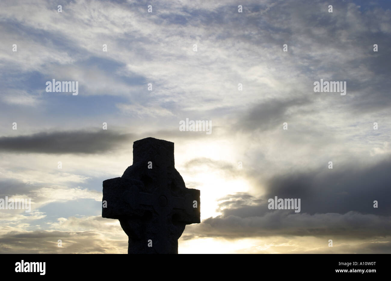 A gravestone silhoutted against a dramatic sky in Troon cemetery ...