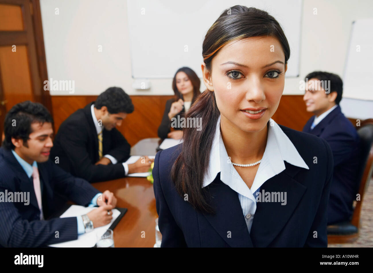 Portrait of a businesswoman with four business executives sitting ...