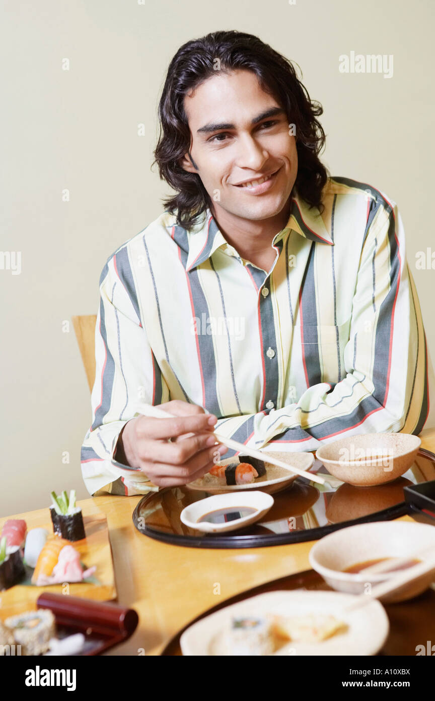 Portrait of a young man sitting at the dining table and smiling Stock ...