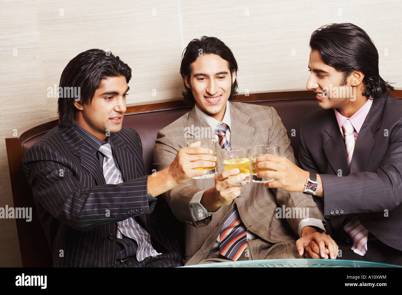 Smiling businessmen toasting glasses hi-res stock photography and ...