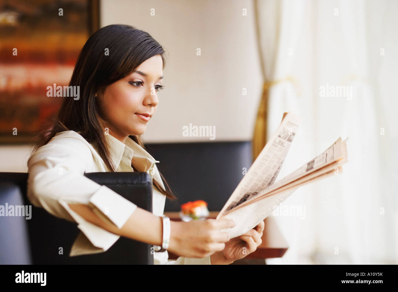 Side profile of a businesswoman reading a newspaper Stock Photo - Alamy
