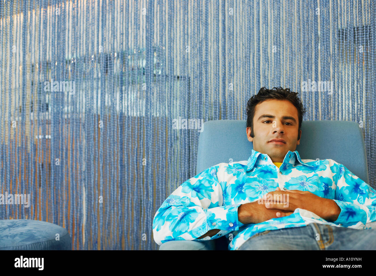 Young man reclining in an armchair Stock Photo - Alamy