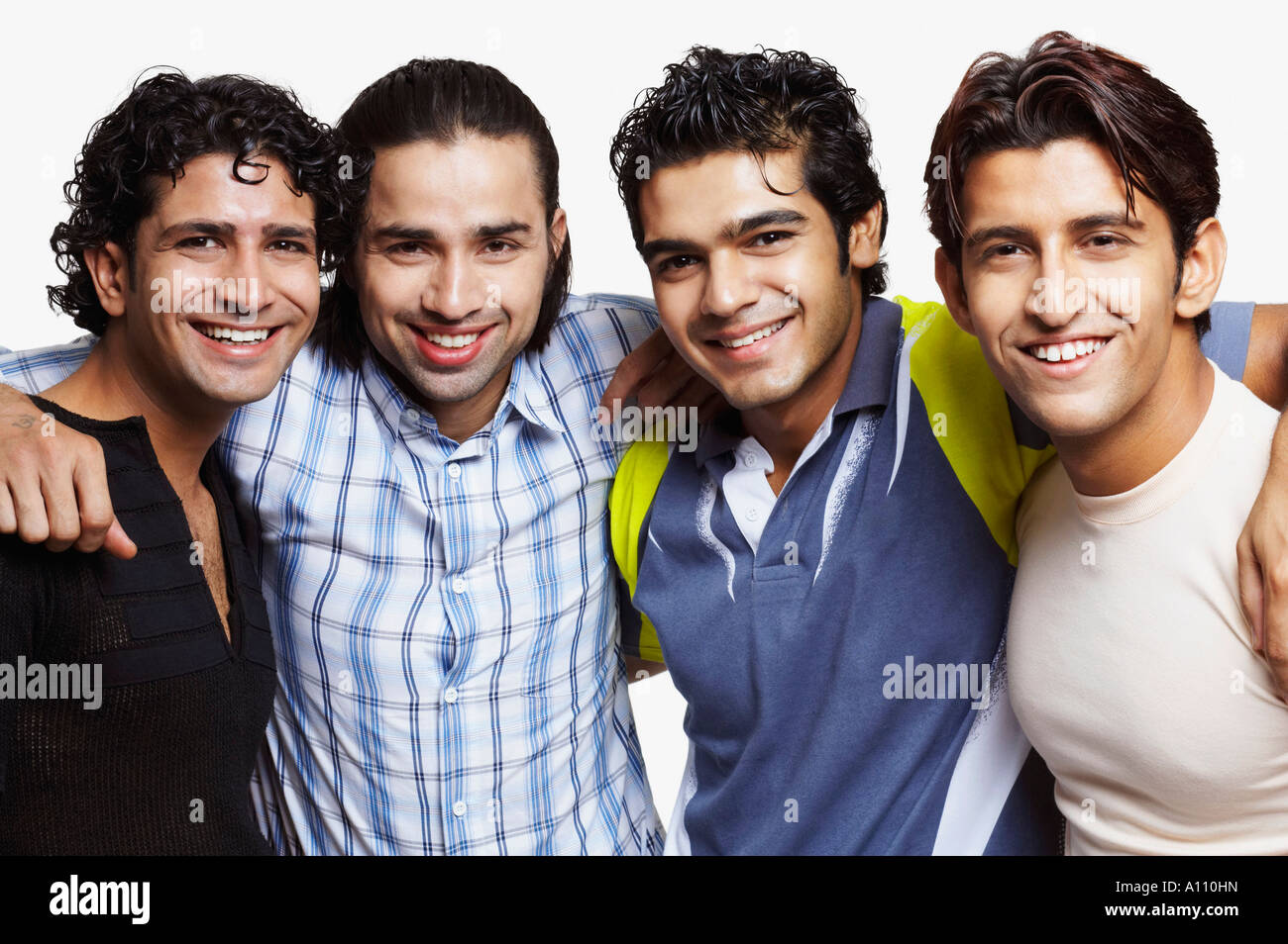 Portrait of four young men standing with their arms around each other ...