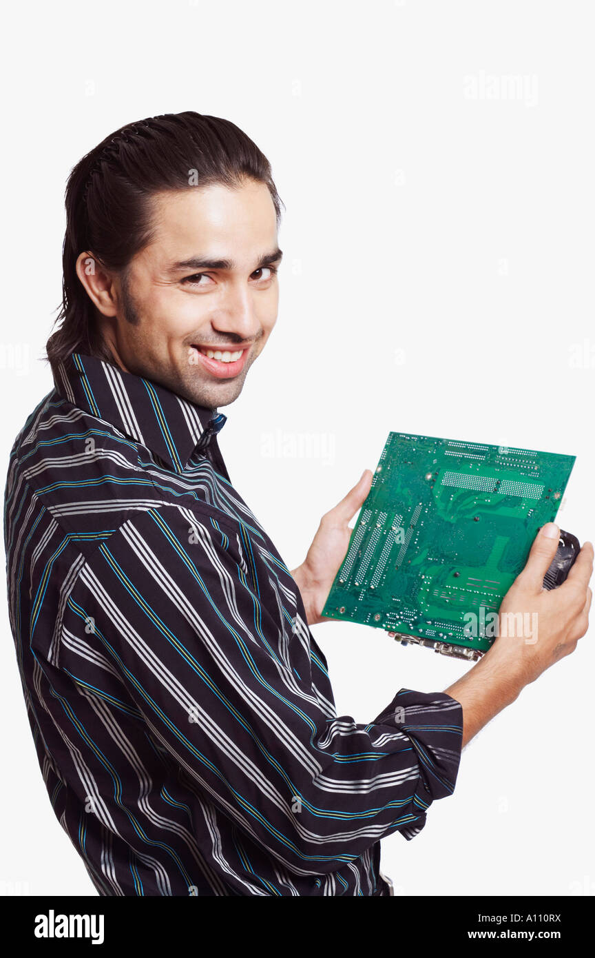 Portrait of a young man holding a circuit board and smiling Stock Photo ...