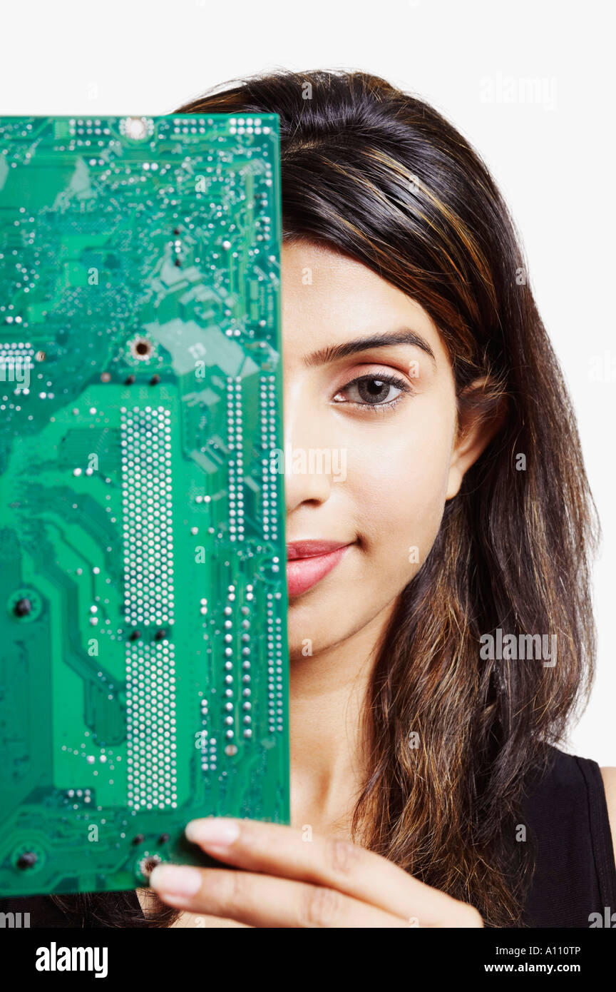 Portrait of a young woman peeking behind a circuit board Stock Photo ...