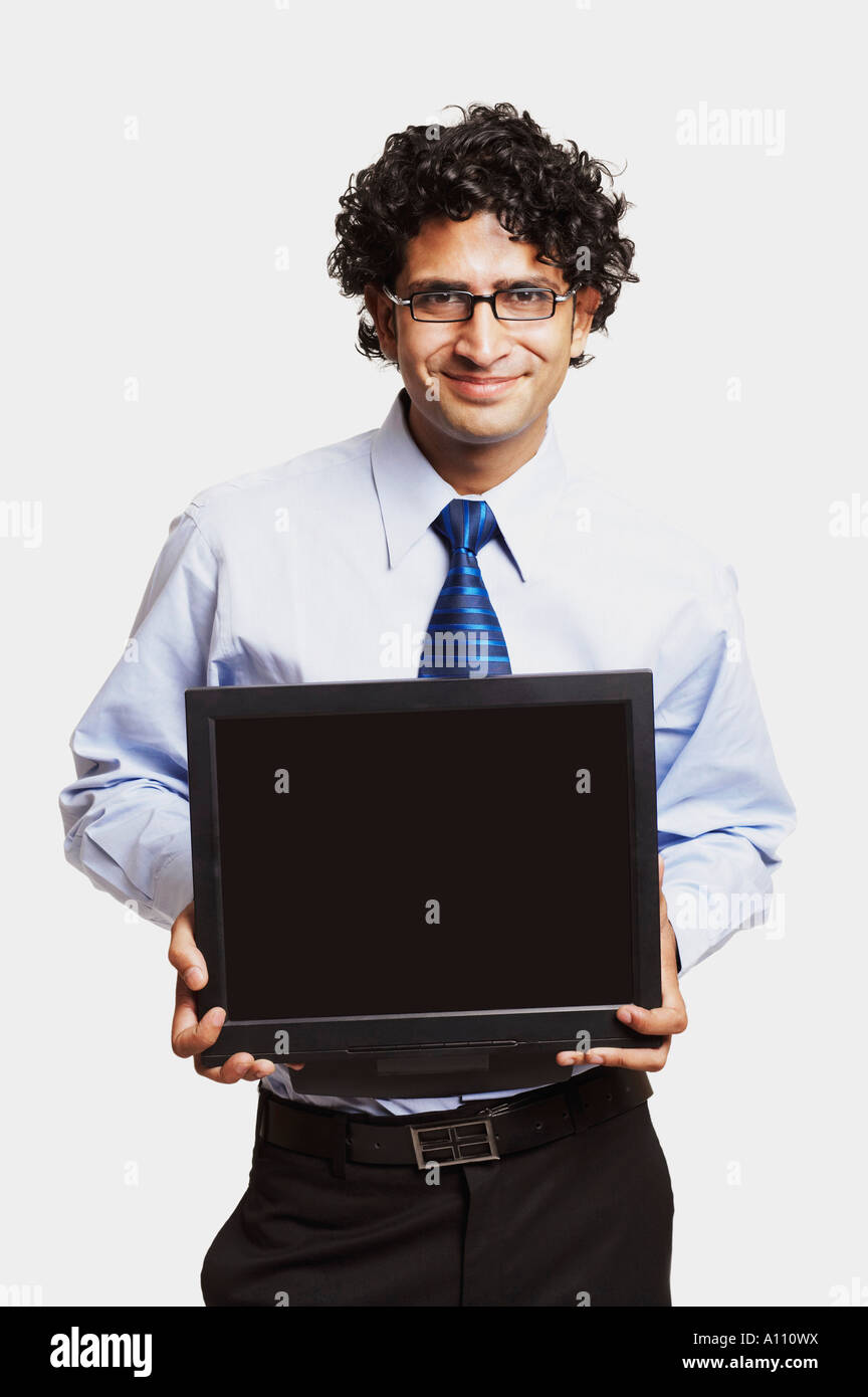 Portrait of a businessman holding a flat screen computer monitor and ...