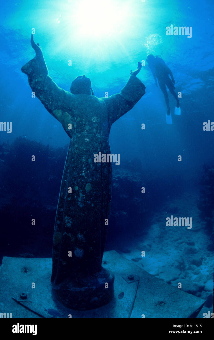 A SCUBA DIVER IS SILHOUETTED BEHIND THE RAISED ARMS OF THE CHRIST ...