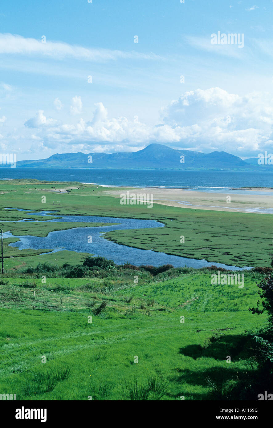 Hills stand beyond winding patches of water separated by lush green ...