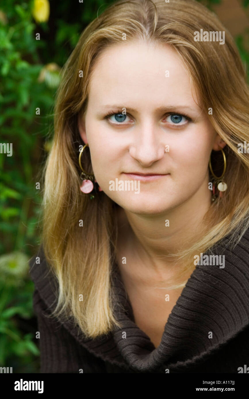 a portrait of a pretty young woman with a ghost of smile upon her face ...