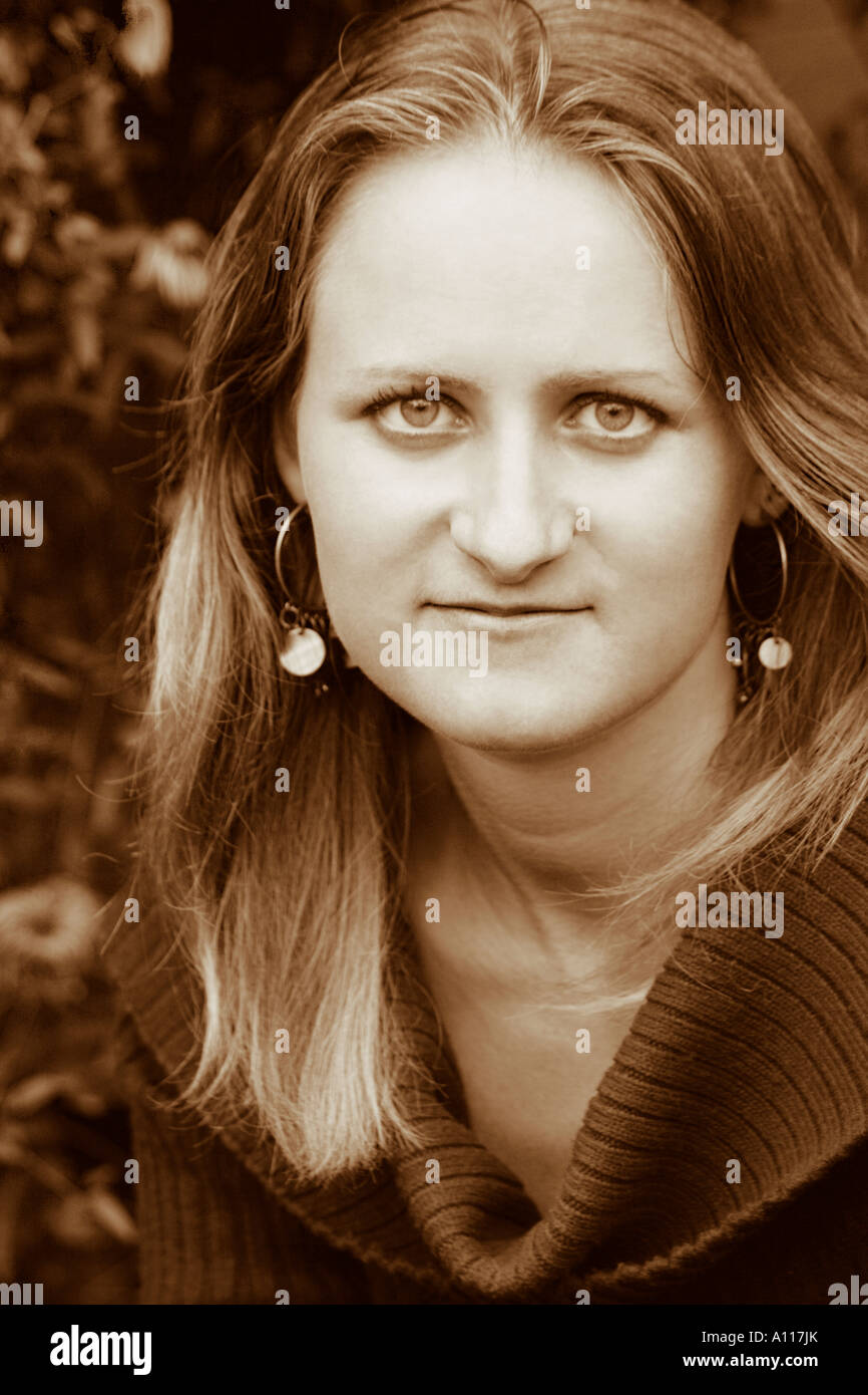 a portrait of a pretty young woman with a ghost of smile upon her face ...