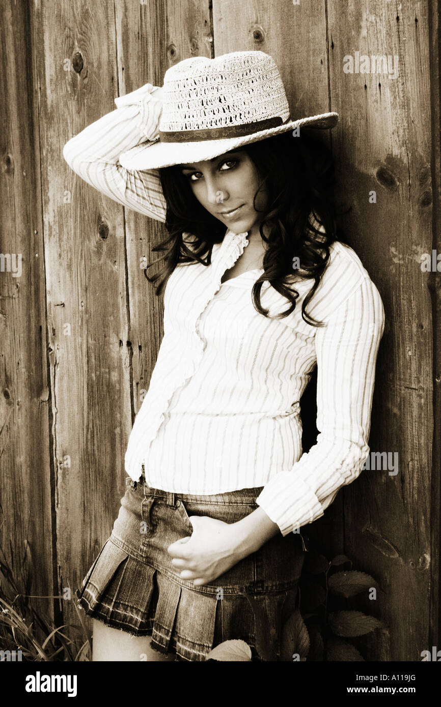 Woman leaning against barn Stock Photo - Alamy