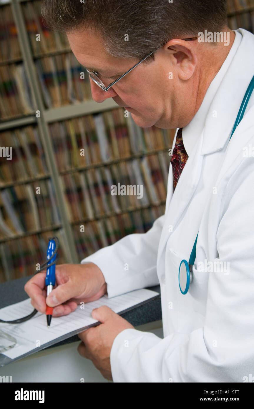 Doctor writing on patient chart Stock Photo - Alamy