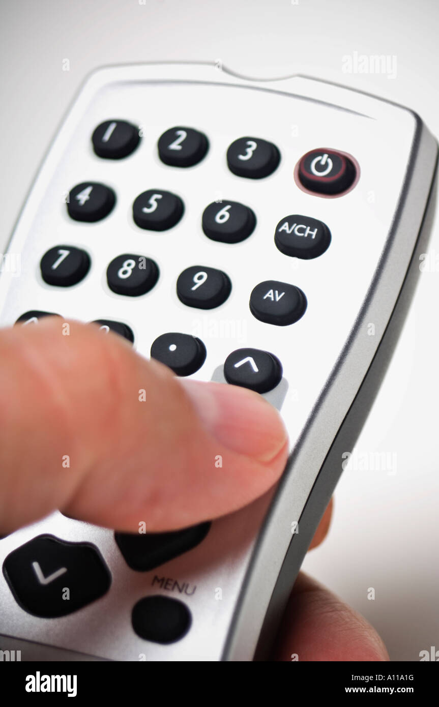 Man changing TV channel with remote control Stock Photo - Alamy