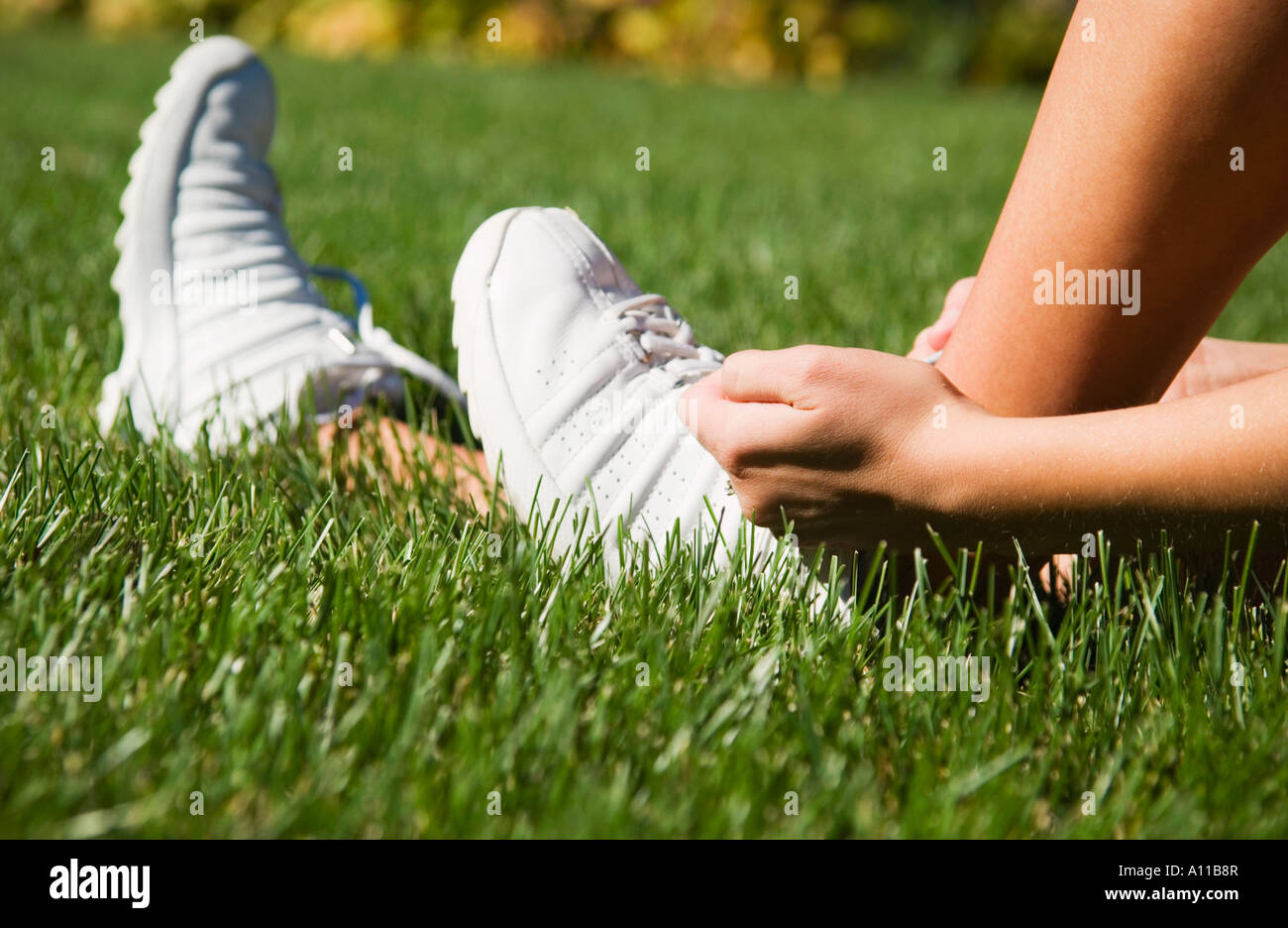 Woman tying her shoes Stock Photo - Alamy