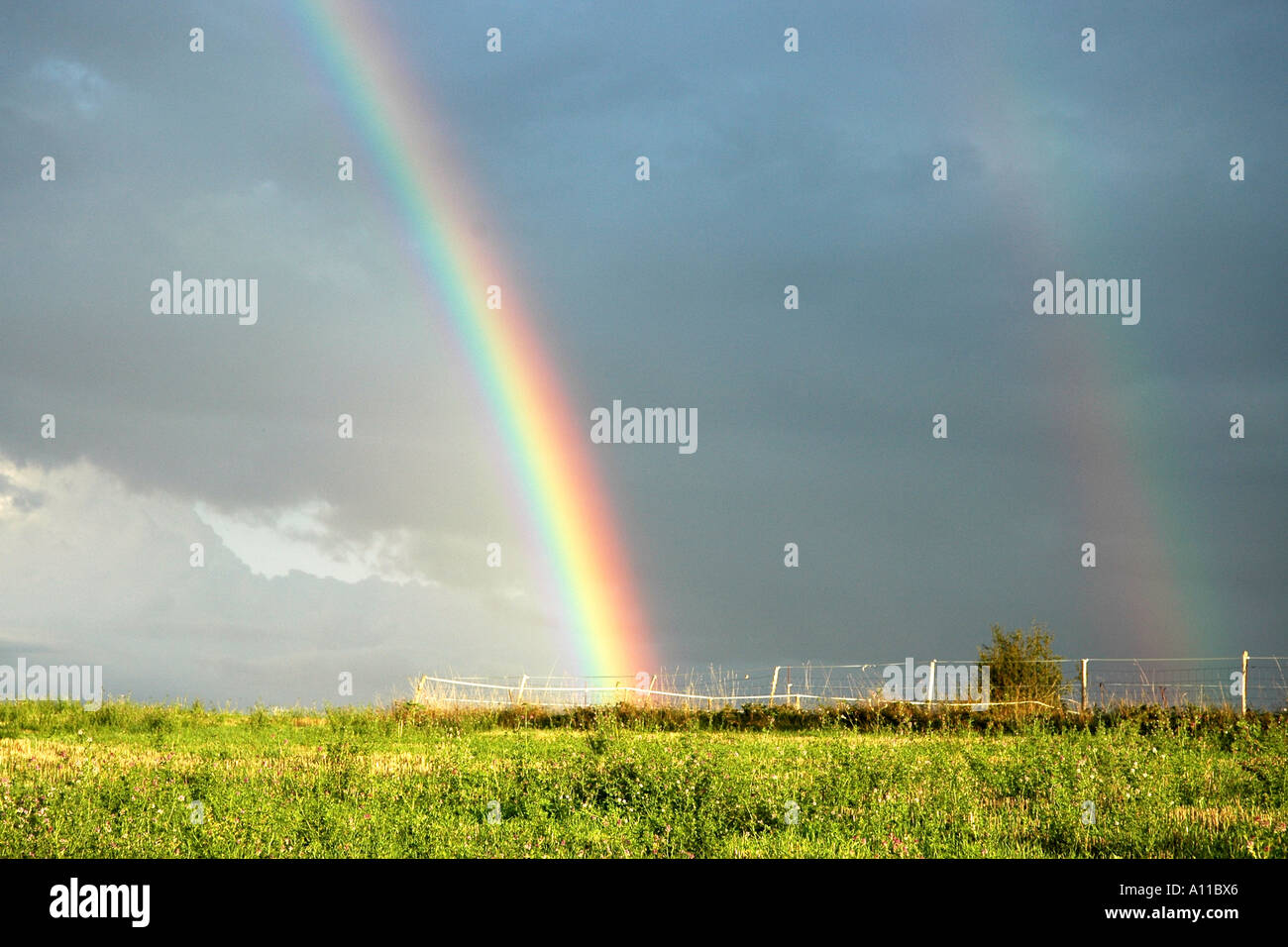 A double rainbow shines brightly over a French field Stock Photo - Alamy
