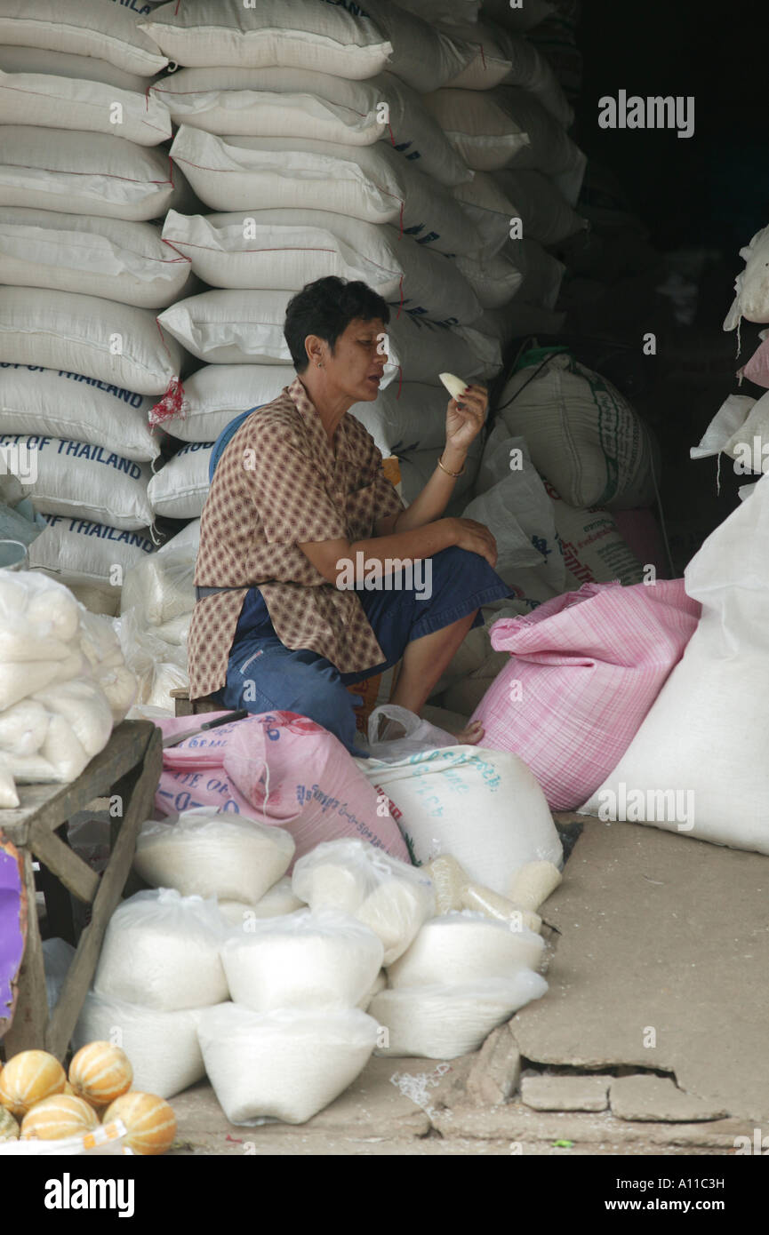 Rice trader surrounded by sacks of rice at Chiang Saen Stock Photo - Alamy