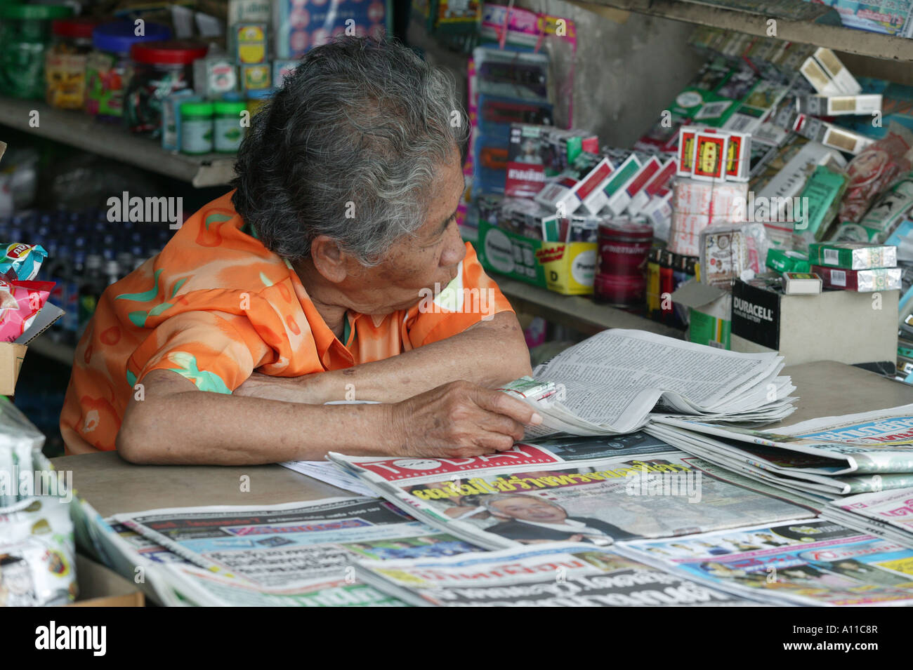 Woman selling newspapers from a kiosk in Chiang Mai Stock Photo - Alamy