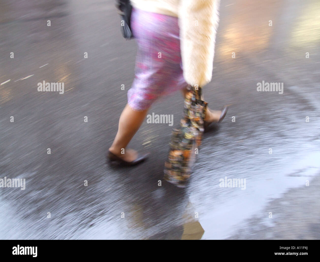 person walking in rain in town Stock Photo - Alamy
