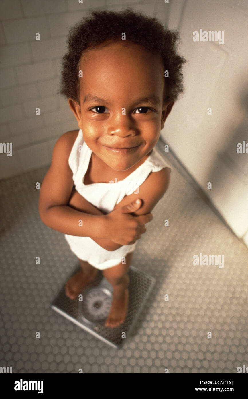 Boy standing on scale Stock Photo - Alamy