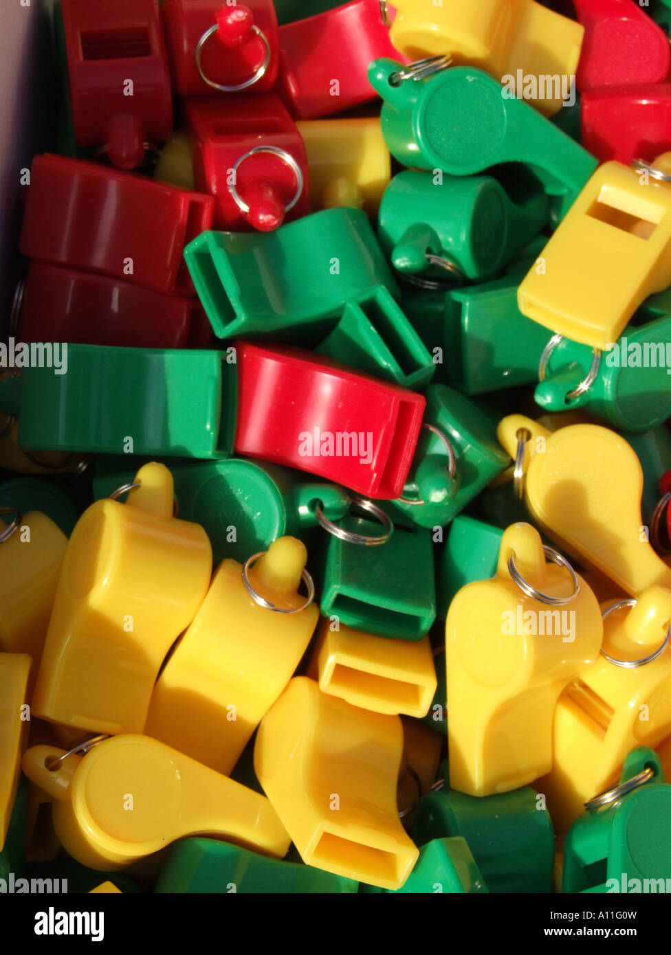 box of colourful plastic whistles Stock Photo - Alamy
