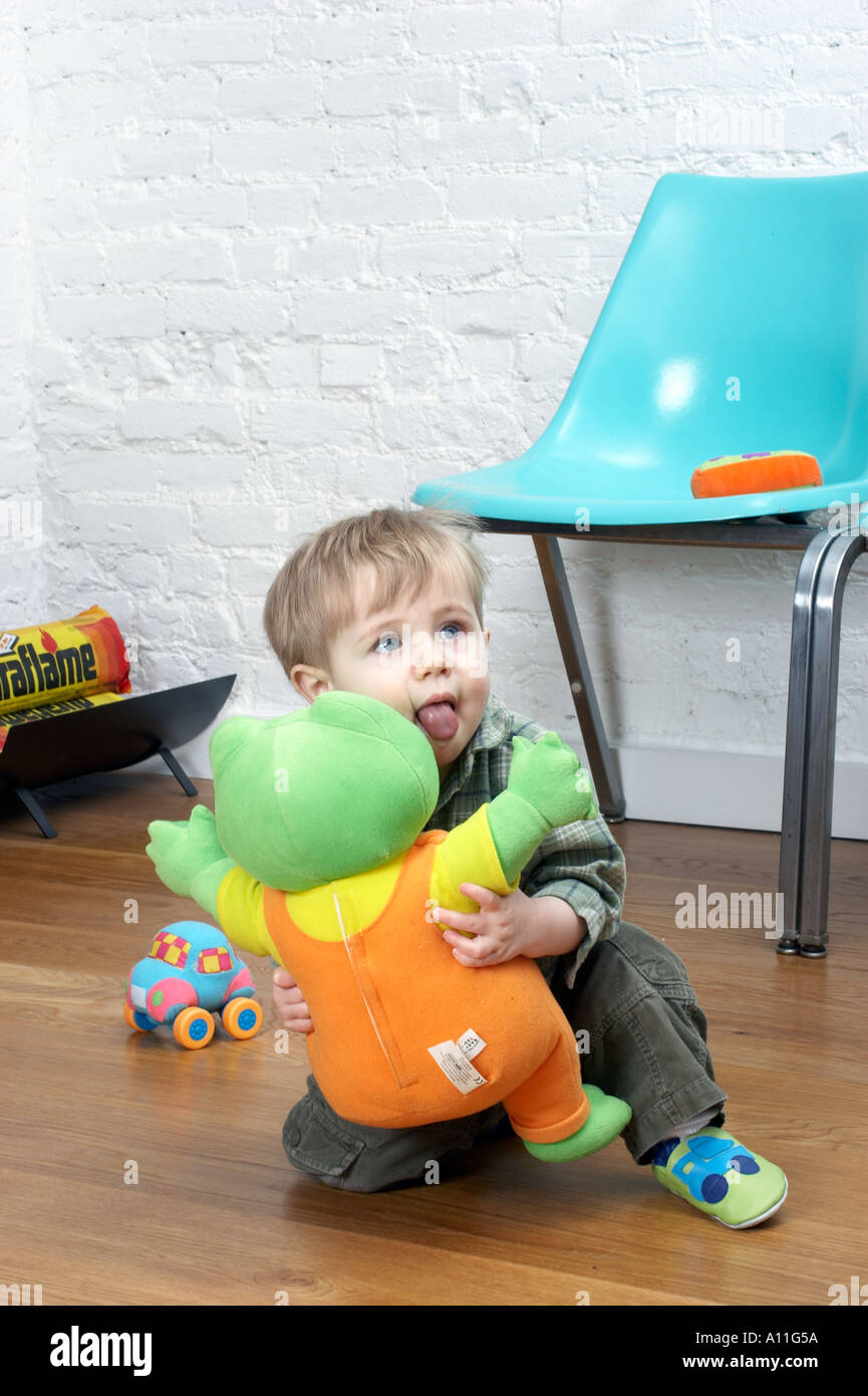 happy baby boy plays with stuffed animal frog on christmas vertical ...