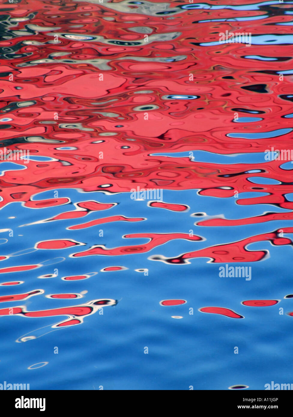 red boat pattern reflected on water ripples Stock Photo - Alamy