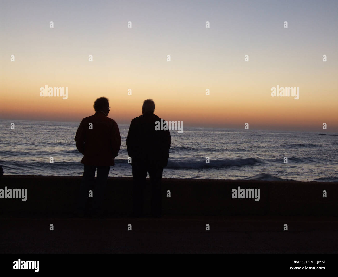 people relaxing by beach promenade at night Stock Photo - Alamy