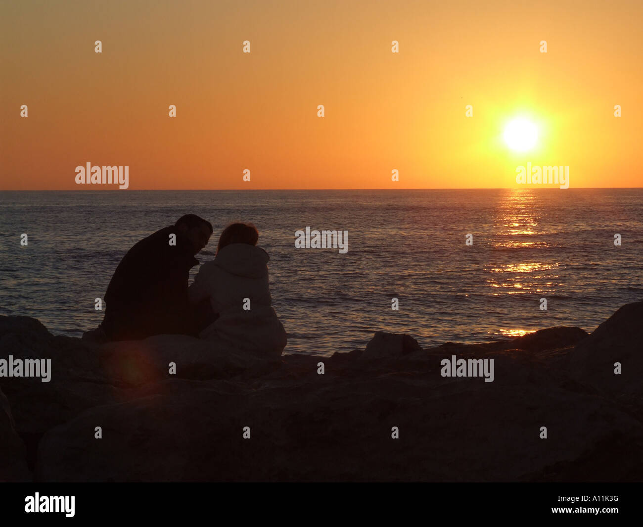 couple having an argument by sea with beautiful red sunset Stock Photo ...