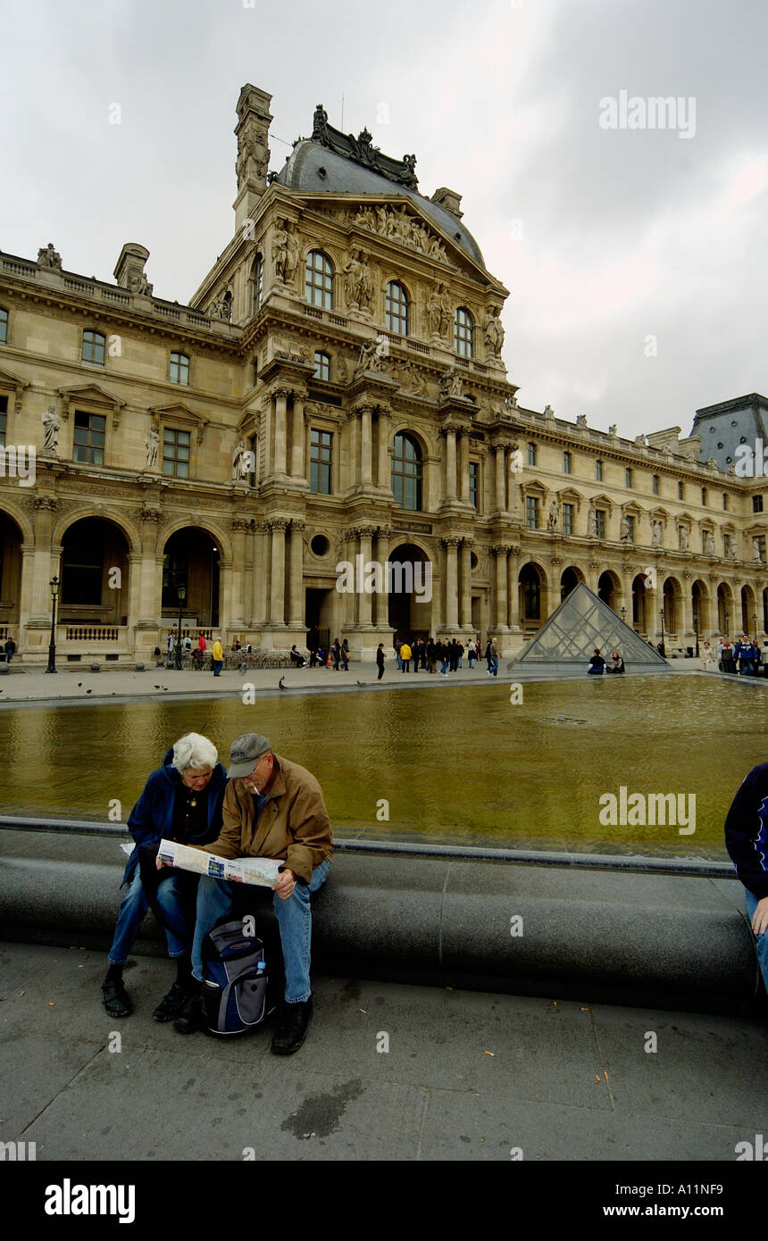 Tourists checking map by Louvre in Paris France Stock Photo - Alamy