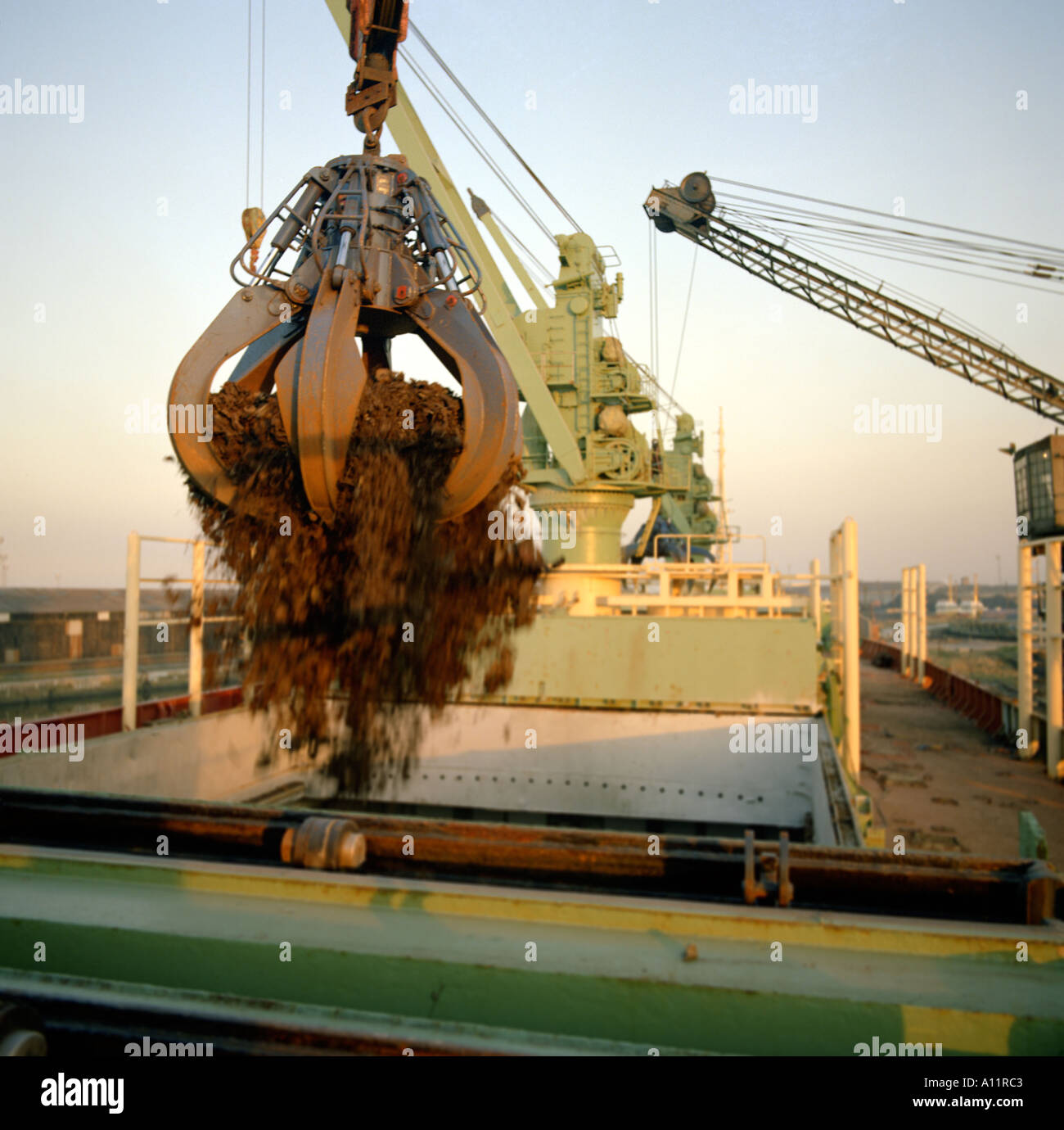 Loading scrap metal into a ships hold Stock Photo - Alamy