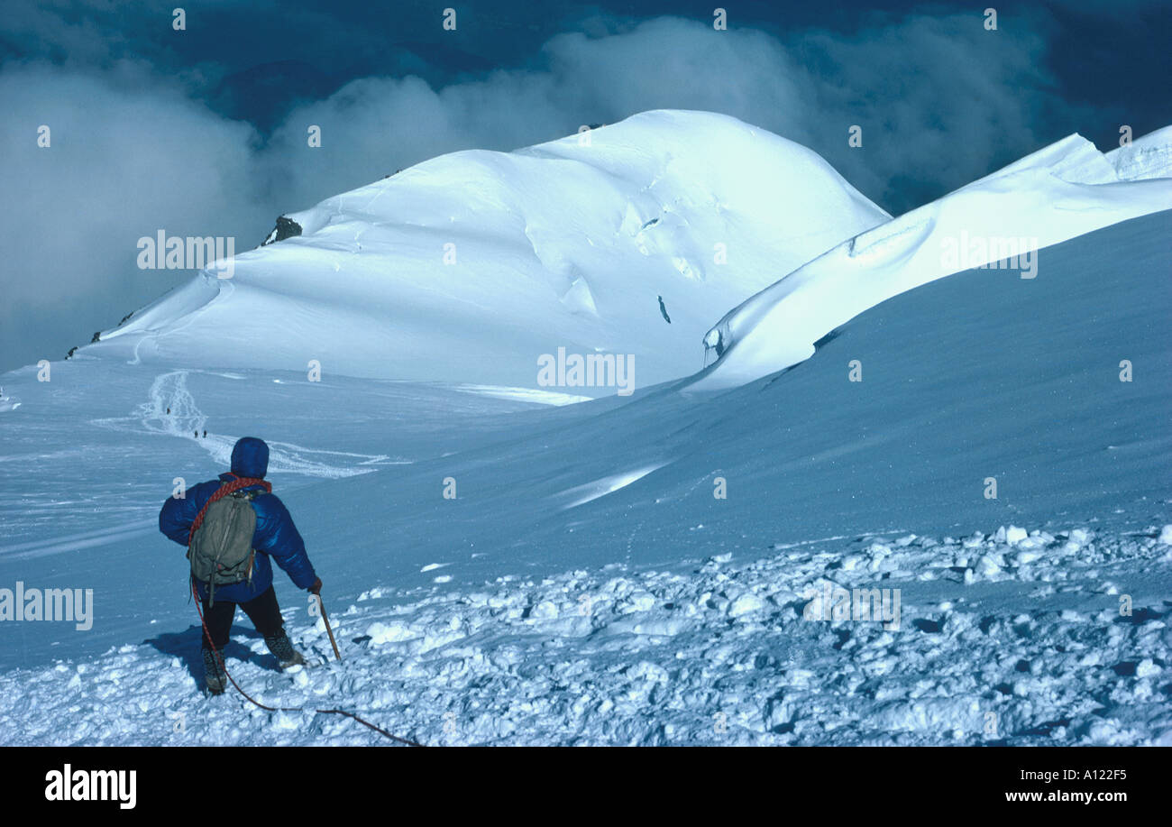 Babs Jackson climbing the summit ridge of Mount Blanc with storm clouds ...