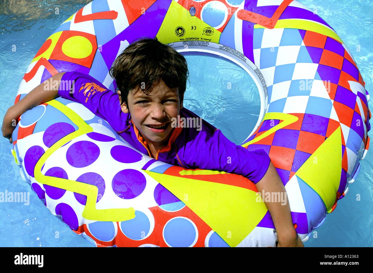 boy in swimming pool playing with inflatable Stock Photo - Alamy